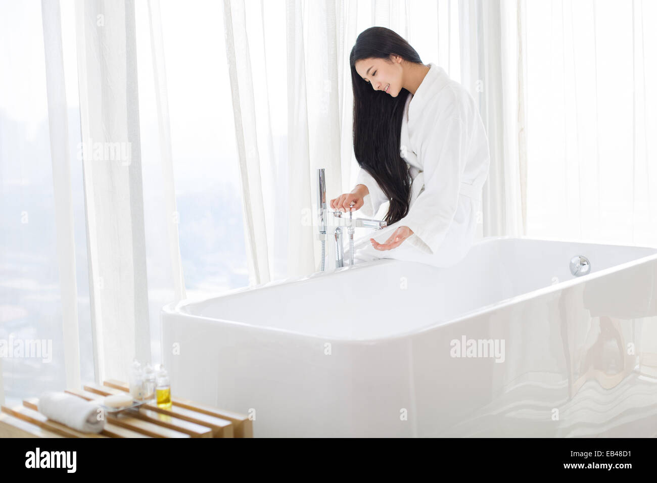 Young woman filling bathtub Stock Photo - Alamy