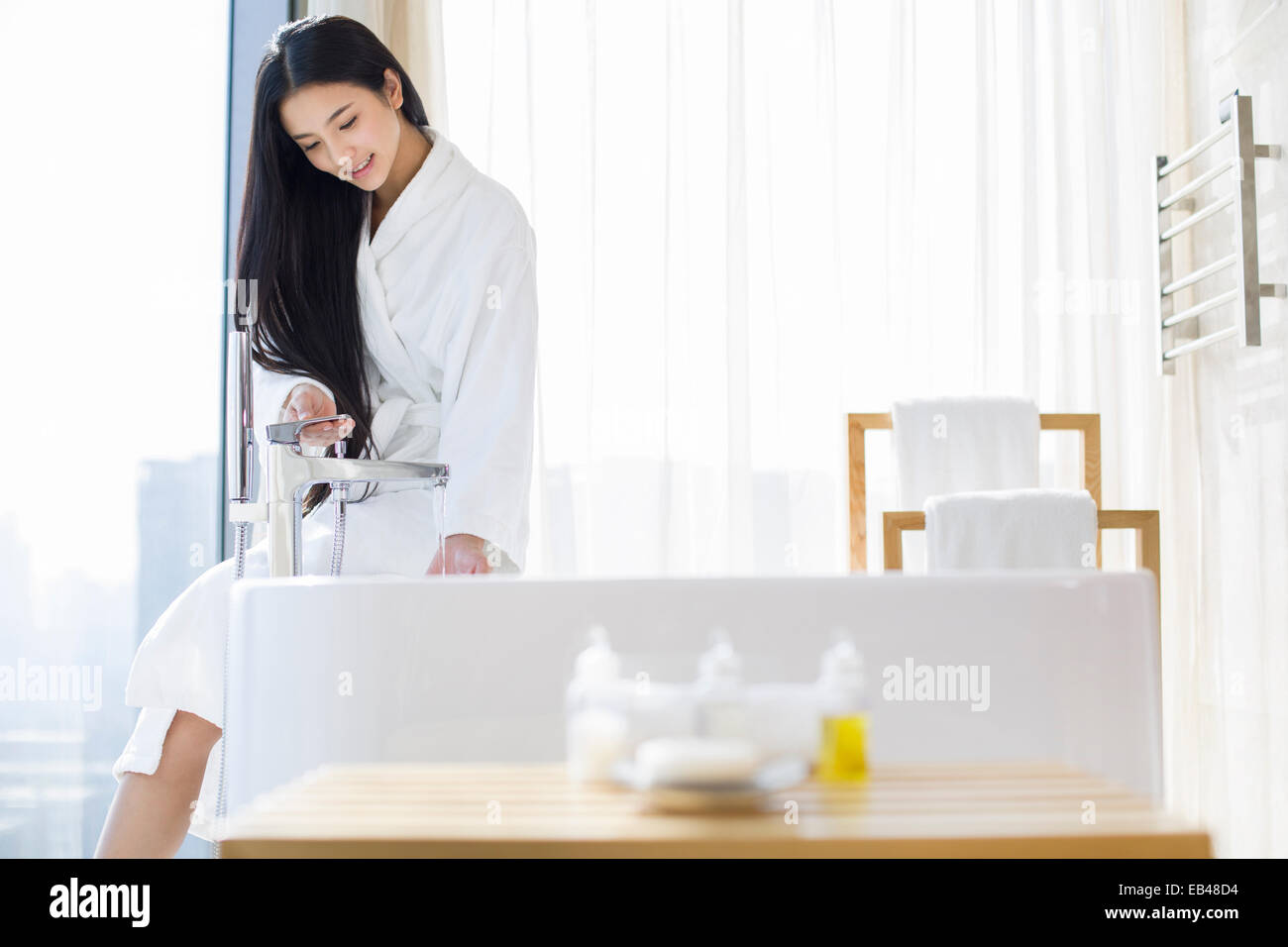 Young woman filling bathtub Stock Photo - Alamy