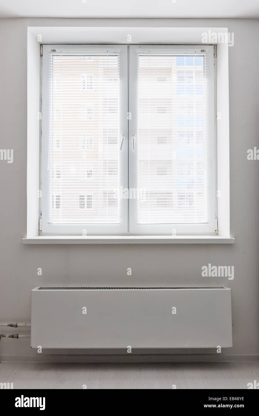 White plastic double door window with radiator under it. Domestic room ...