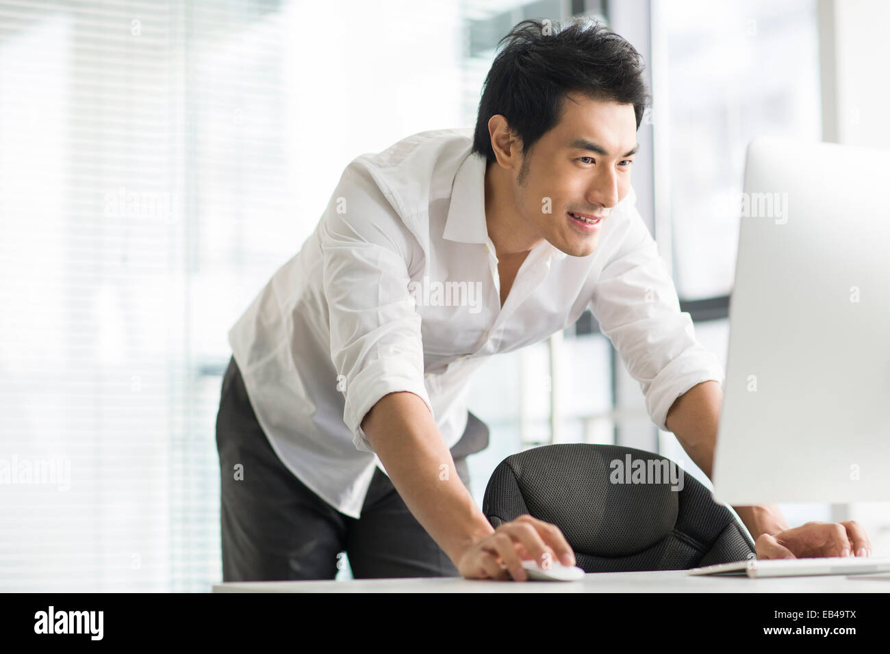 Young businessman using computer in office Stock Photo - Alamy