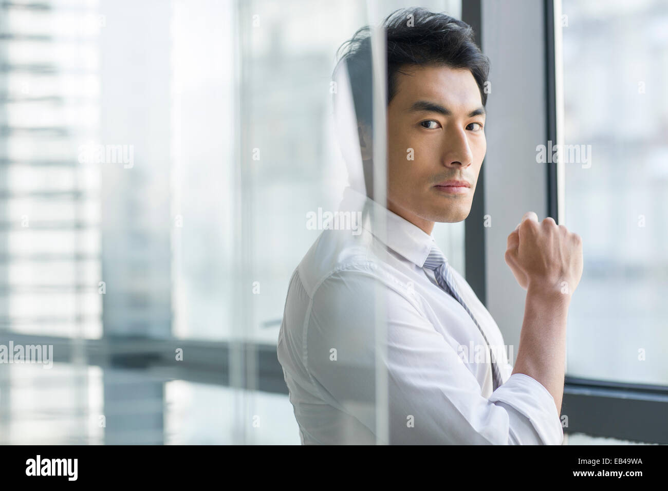 Young businessman standing by window Stock Photo - Alamy