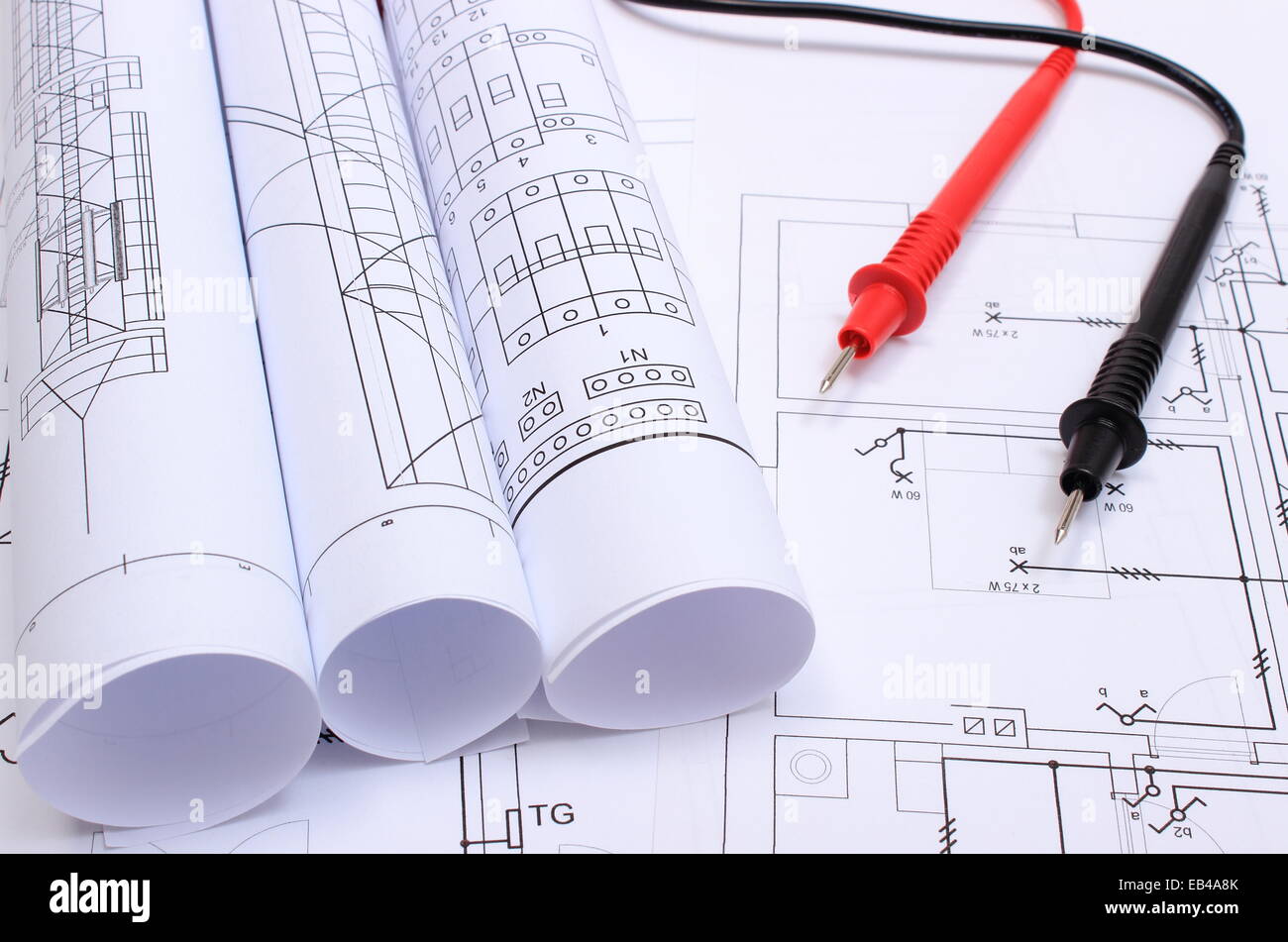 Rolls of electrical diagrams and cables of multimeter lying on ...