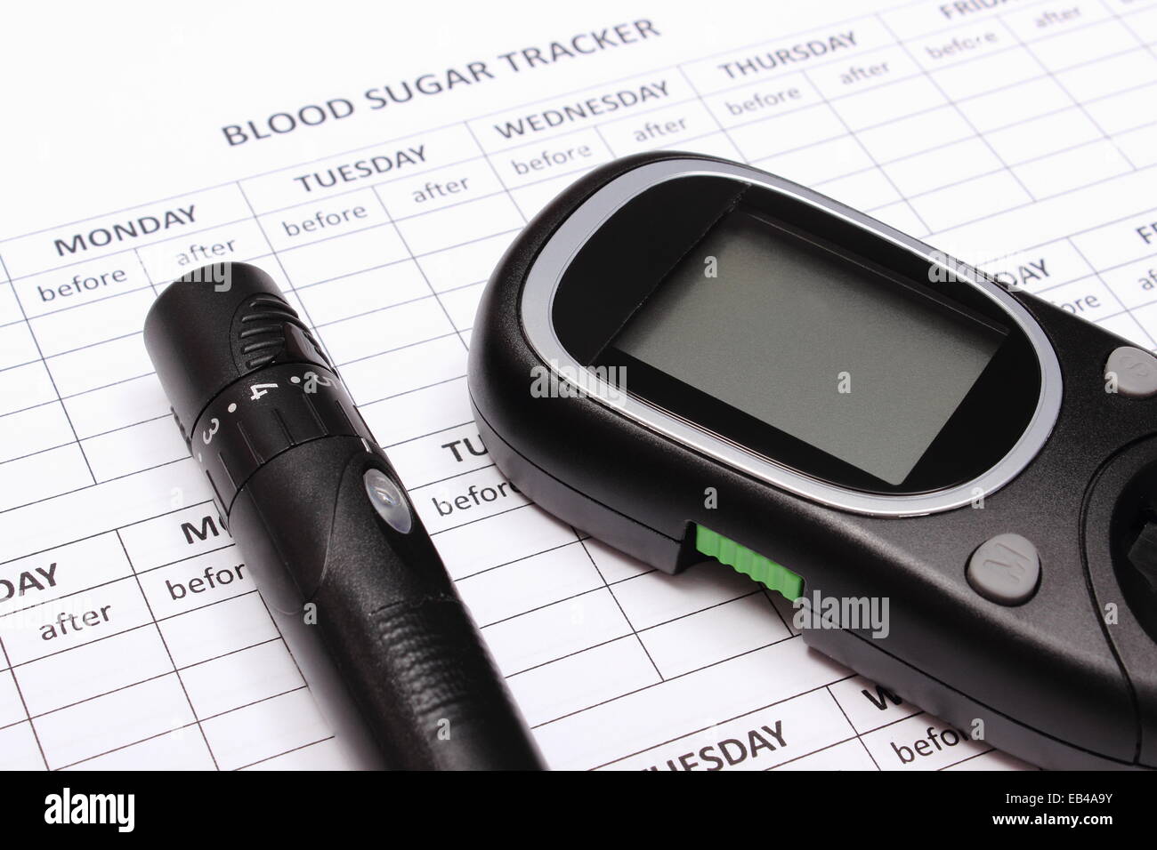 Glucometer and lancet device lying on empty medical forms for ...