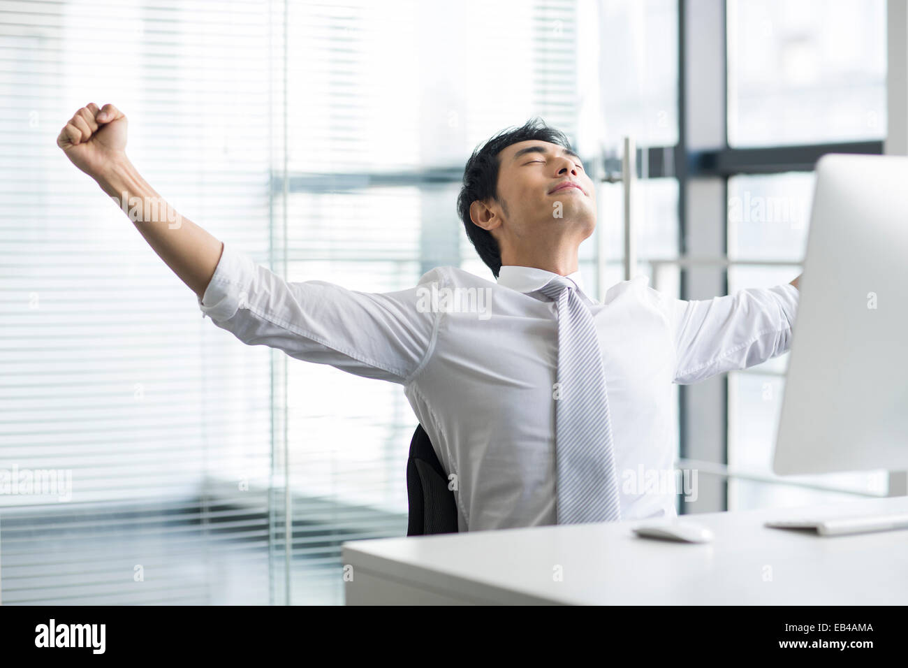 Young businessman stretching in office Stock Photo - Alamy