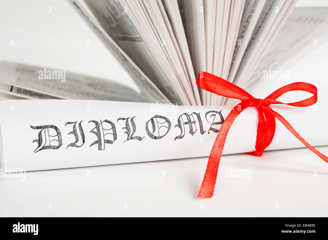 Diploma with red ribbon and open book Stock Photo - Alamy
