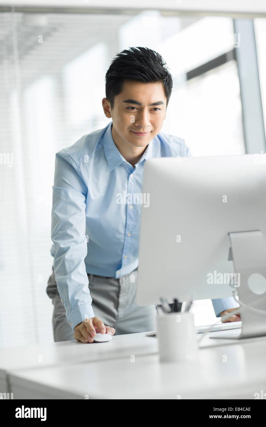 Young businessman using computer in office Stock Photo - Alamy