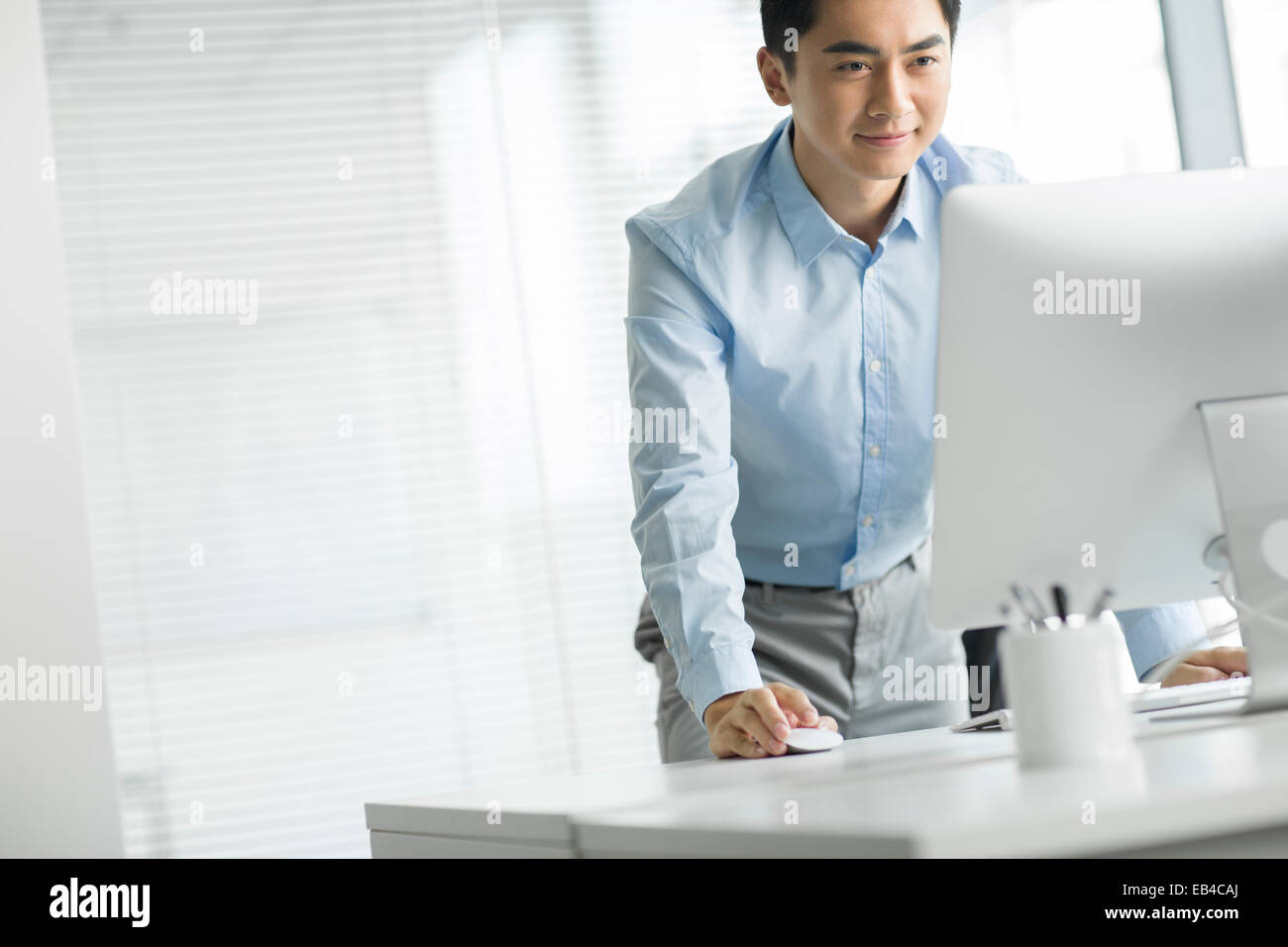 Young businessman using computer in office Stock Photo - Alamy