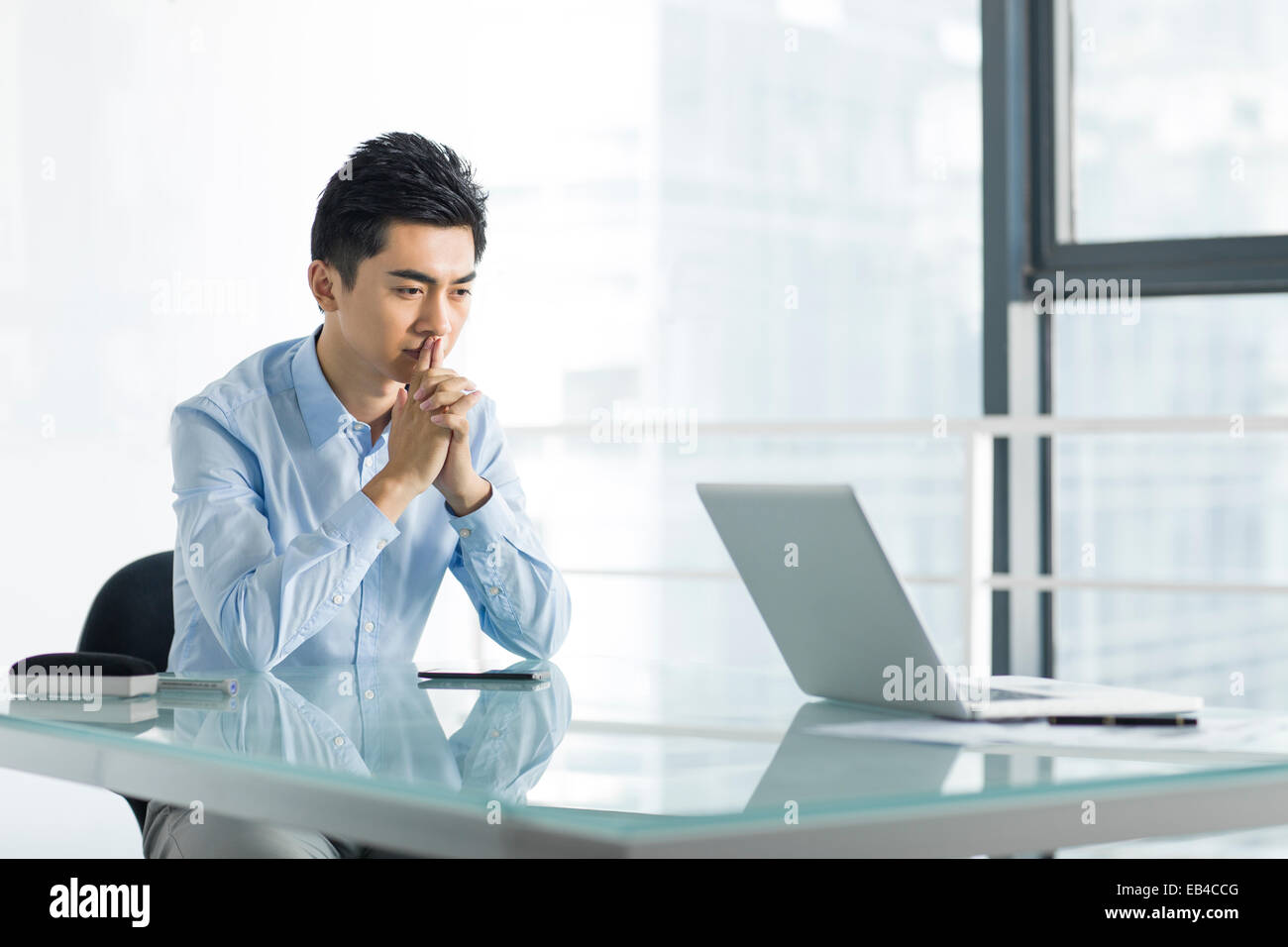 Young businessman thinking in office Stock Photo - Alamy