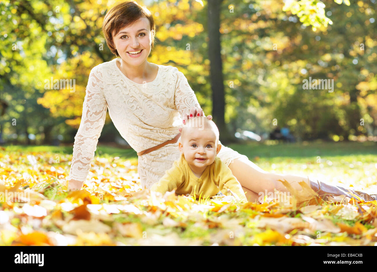 Smiling mother looking after baby Stock Photo - Alamy