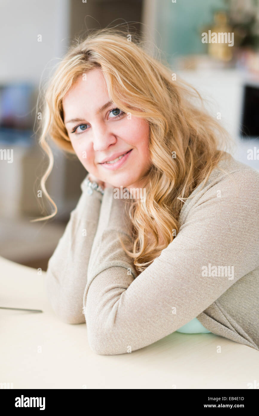 A young woman sitting near table Stock Photo - Alamy