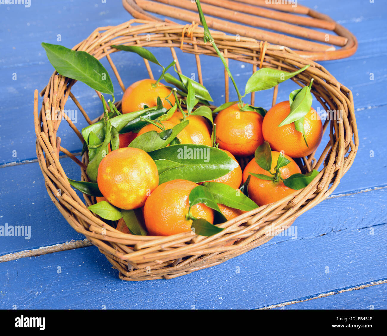 small basket full of mandarin oranges on blue table Stock Photo - Alamy