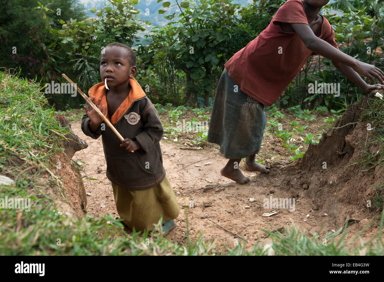 Children walk and play along a path in the hills outside of Kigali ...