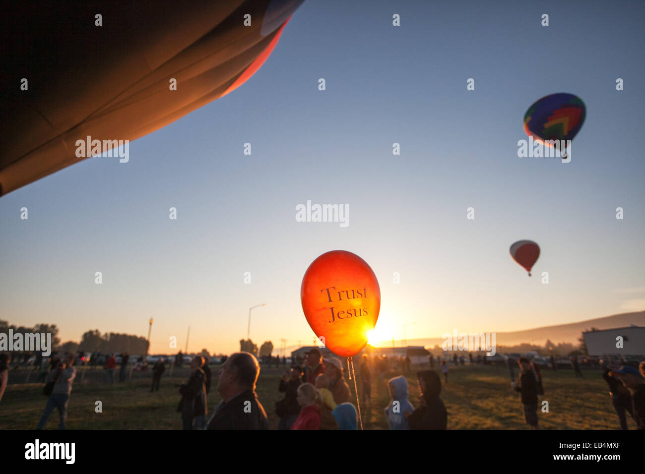 At sunrise, a small helium balloon, proclaiming to Trust Jesus, floats ...
