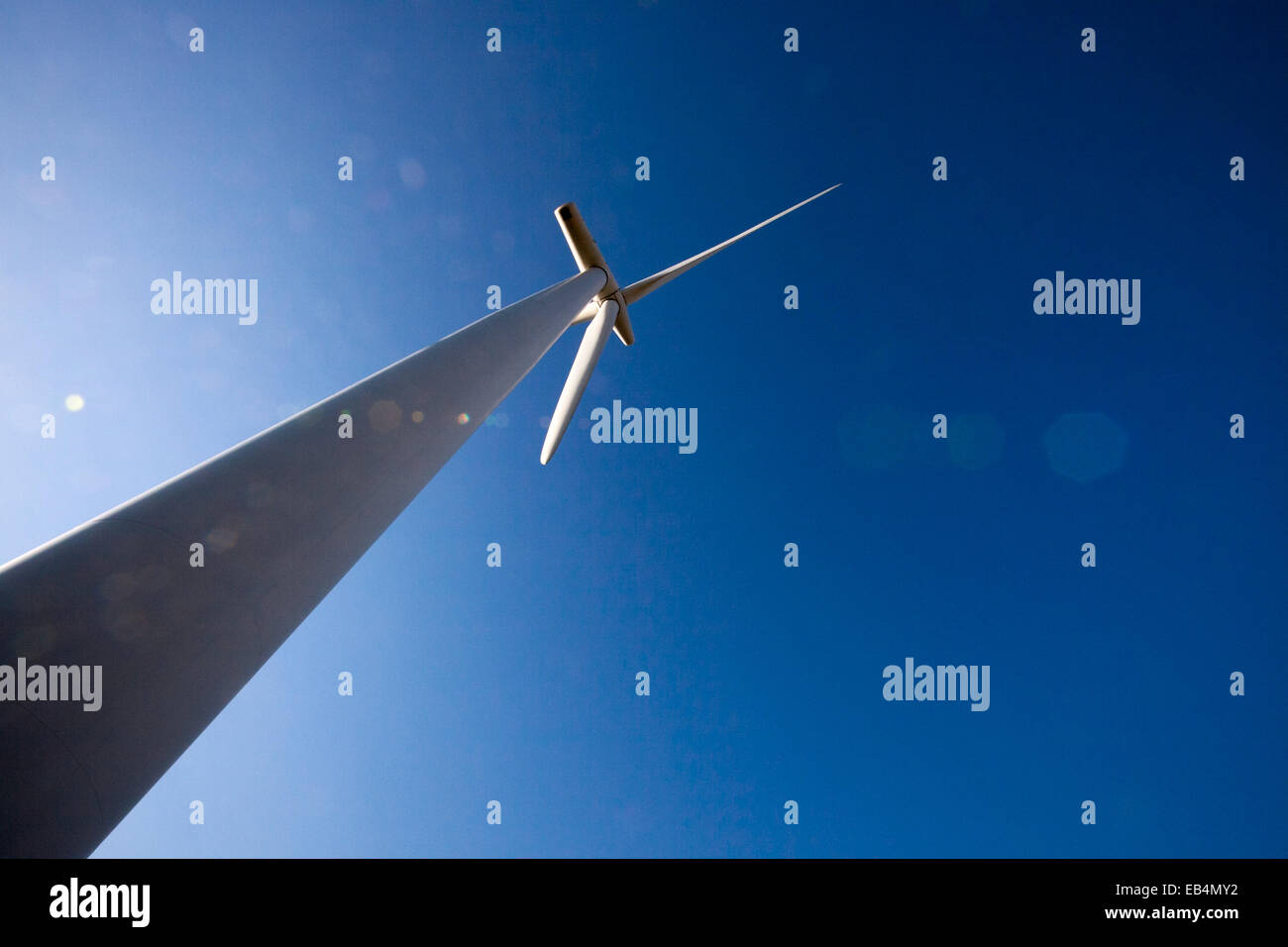 Looking up at a windmill turbine against a crisp blue sky Stock Photo ...
