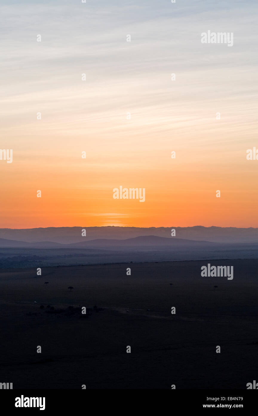 Mist fills the valleys and gullies of the savannah plain as dawn rises ...