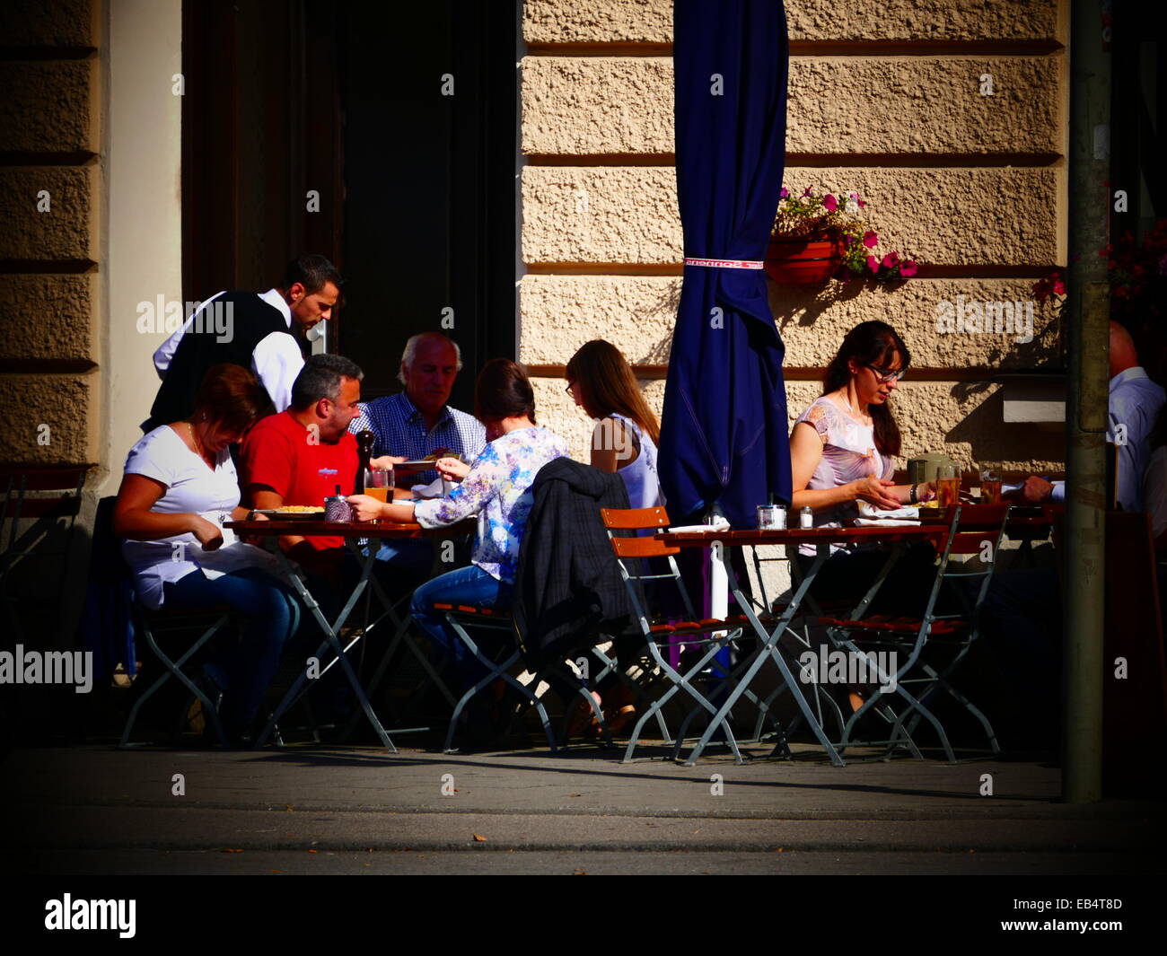 Waiter serving customer at sidewalk pavement Stock Photo - Alamy