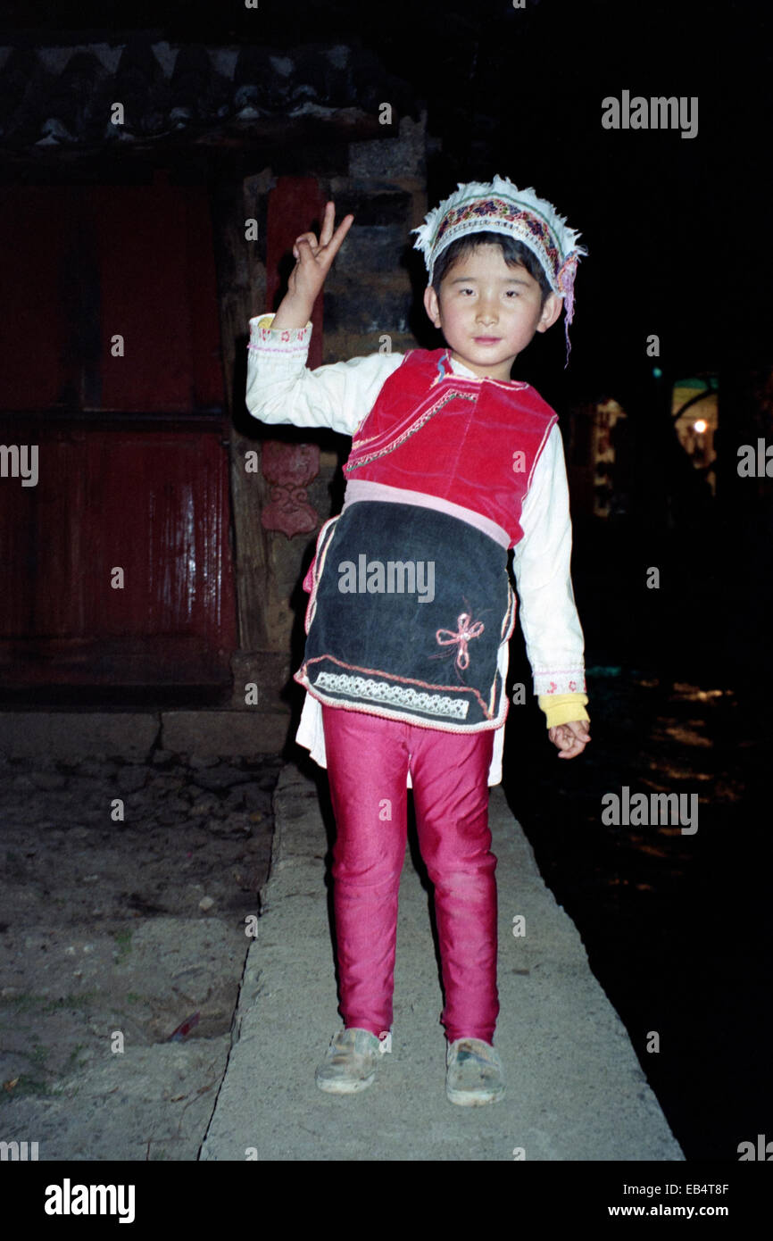 child wearing traditional ethnic minority clothing poses in lijiang ...