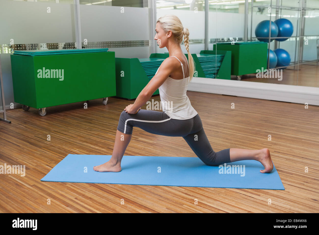 Fit woman doing stretching exercise in gym Stock Photo - Alamy