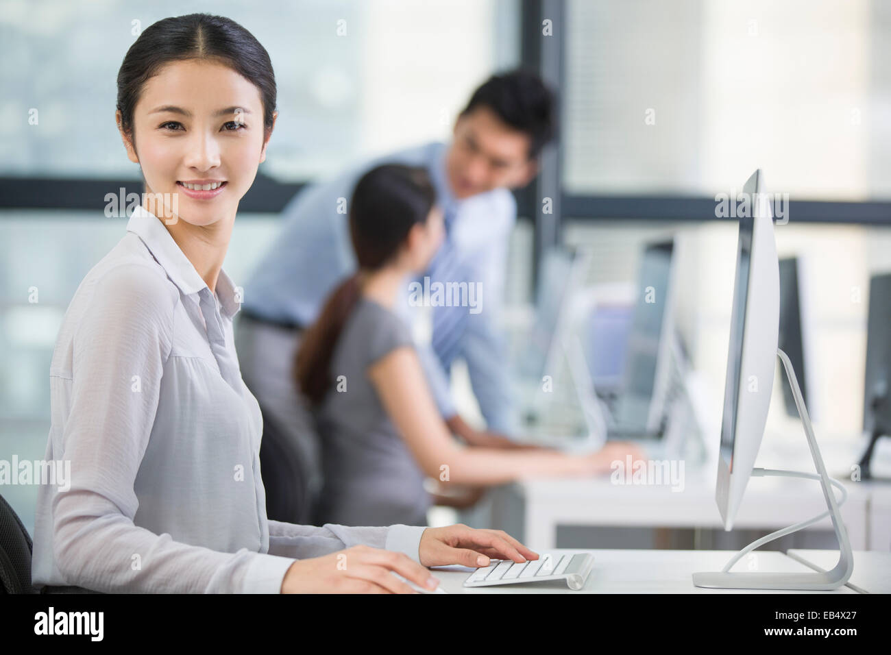 Young businesswoman using computer in office Stock Photo - Alamy