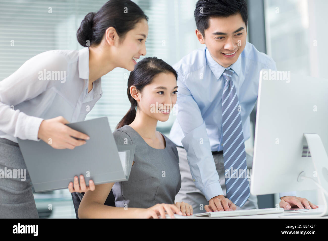 Young business people using computer in office Stock Photo - Alamy