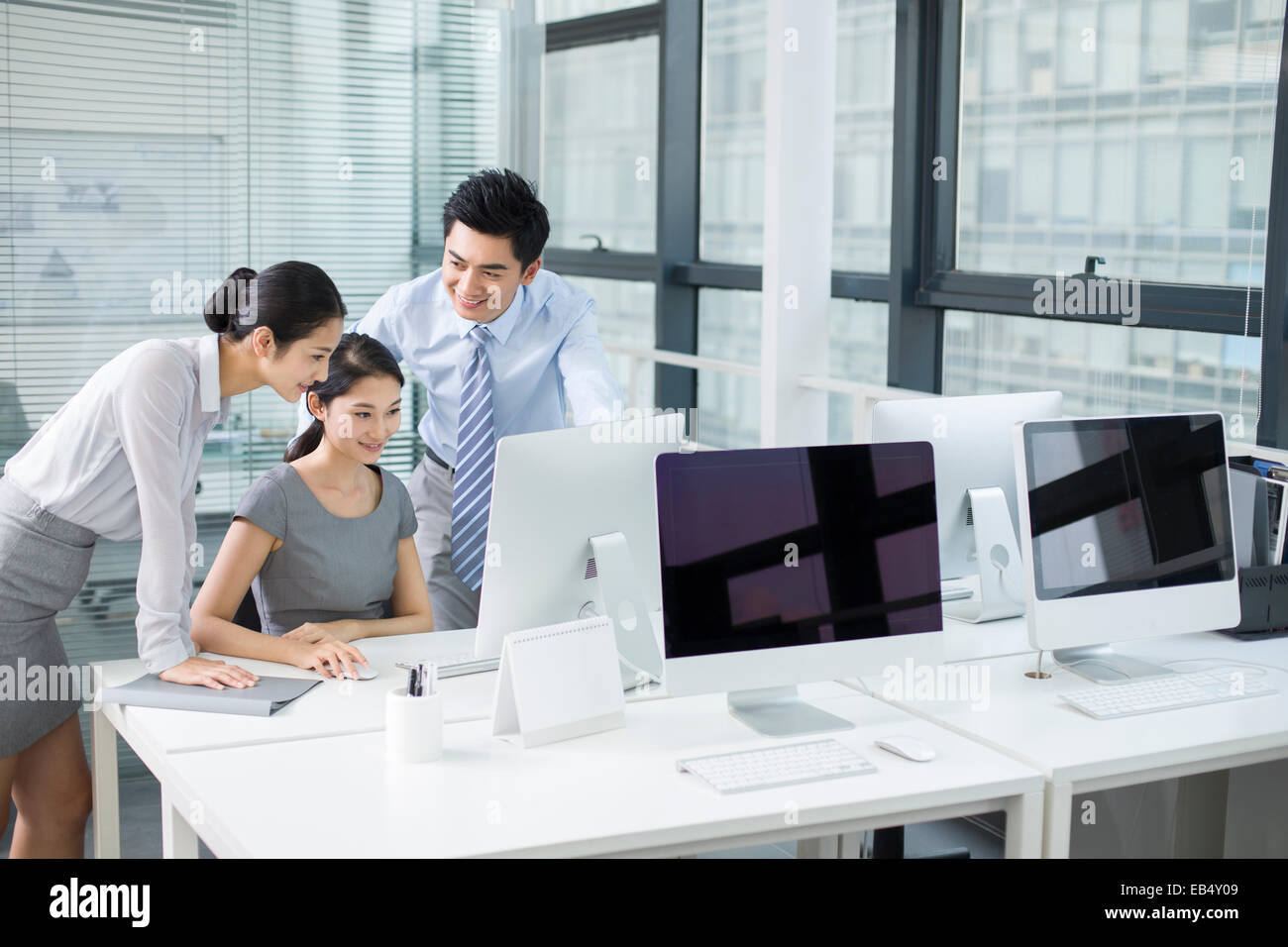 Young business people using computer in office Stock Photo - Alamy