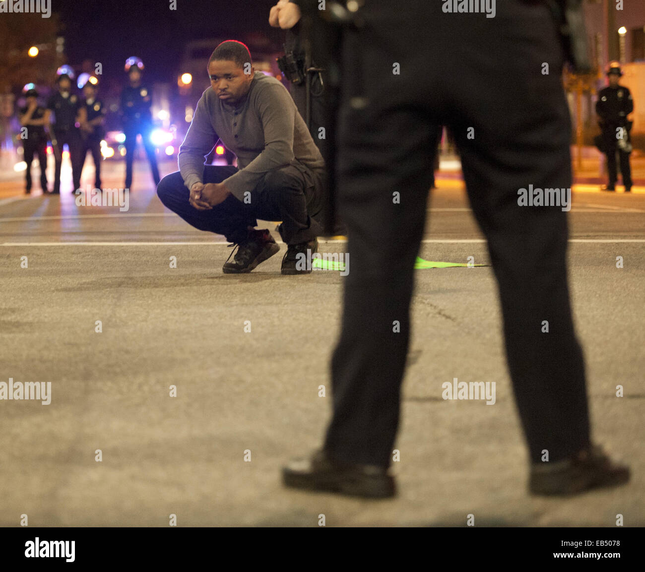 Los Angeles, California, USA. 25th Nov, 2014. A young man kneels down ...