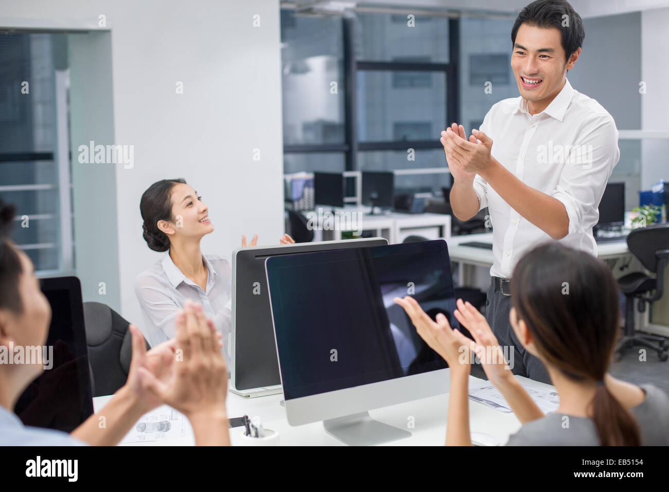 Young business people clapping in office Stock Photo - Alamy