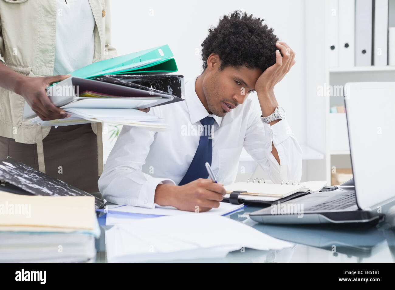 Woman giving pile of ring binders to her exhausted colleague Stock ...