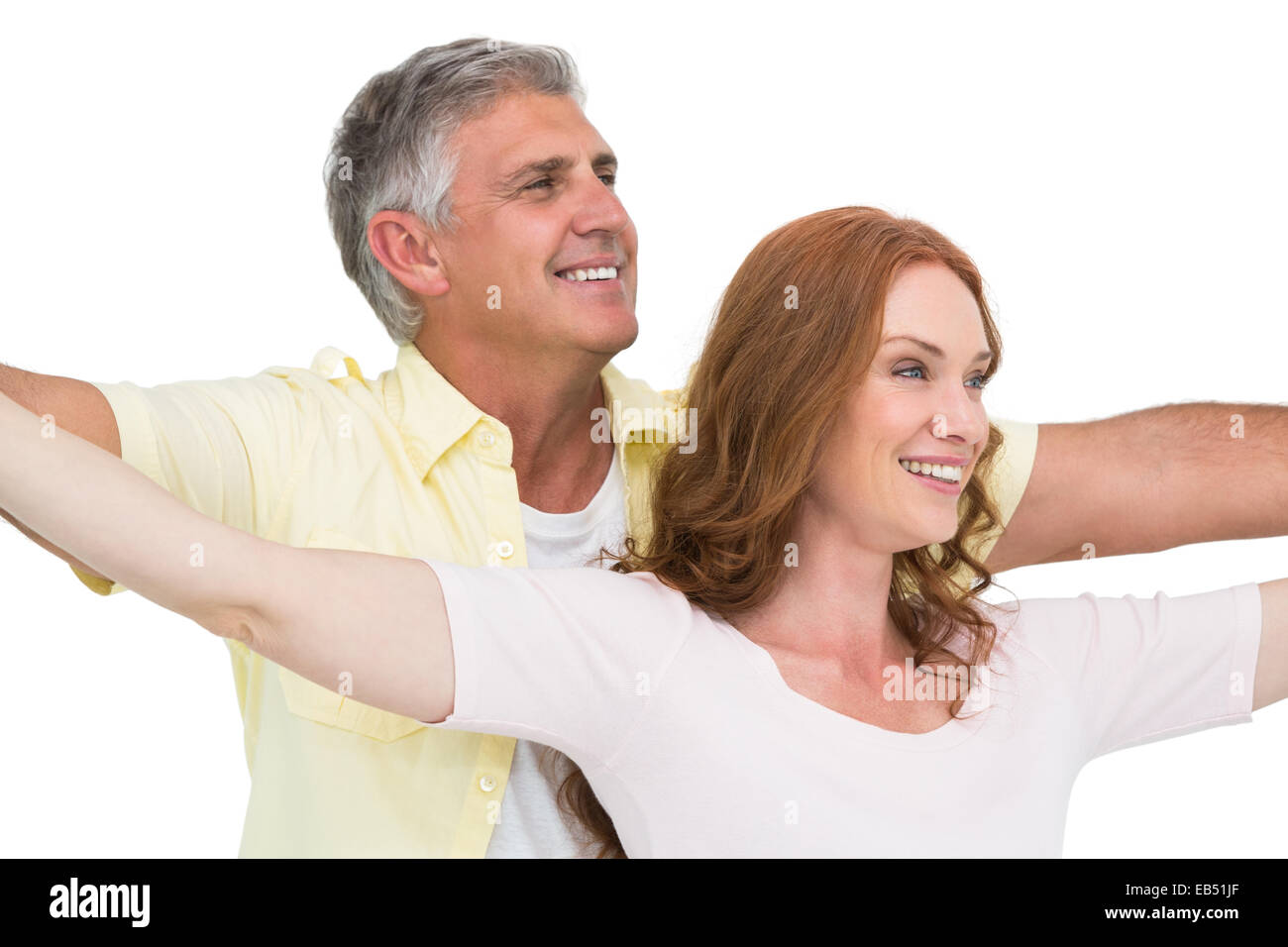 Casual couple smiling with arms raised Stock Photo - Alamy