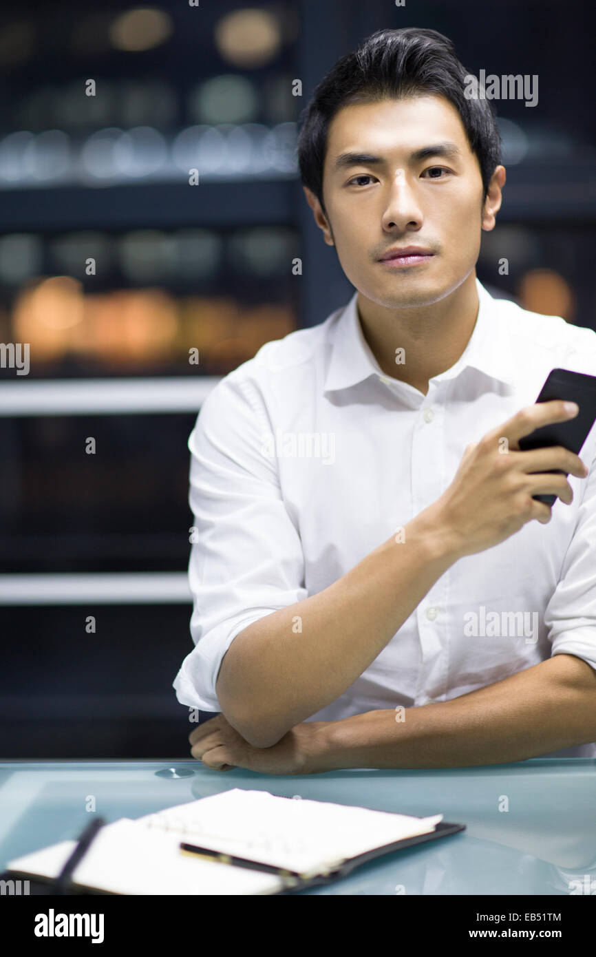 Young businessman using smart phone in office Stock Photo - Alamy