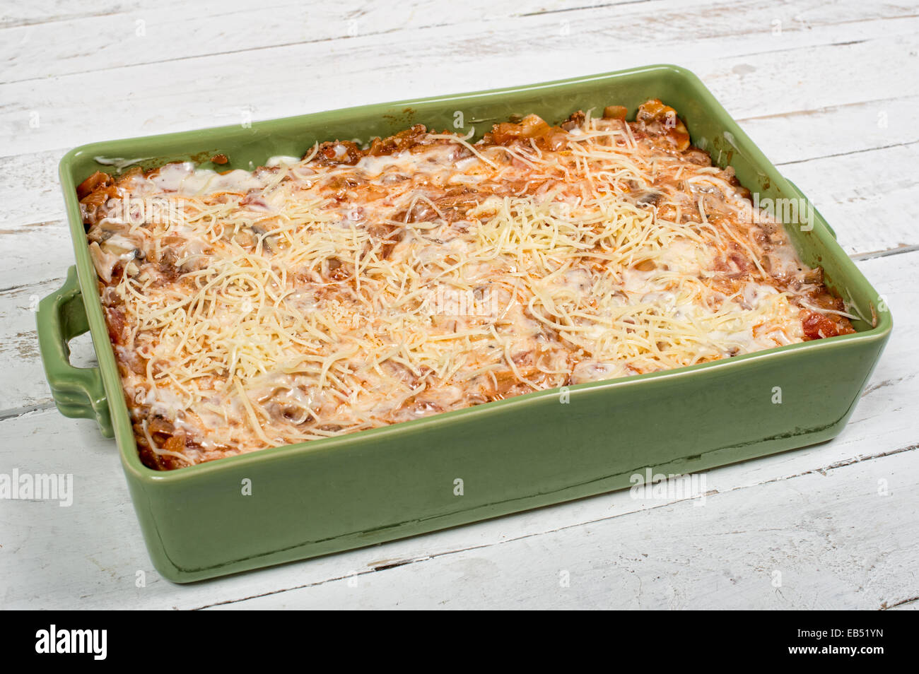 preparation of lasagna in a green dish on white table Stock Photo - Alamy