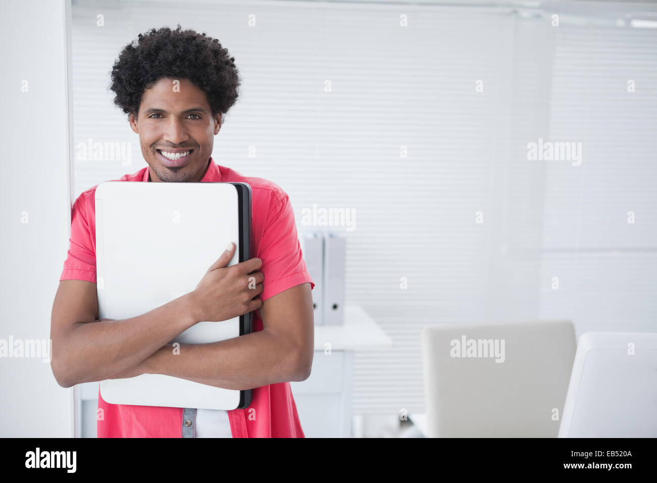 Happy businessman holding his laptop Stock Photo - Alamy