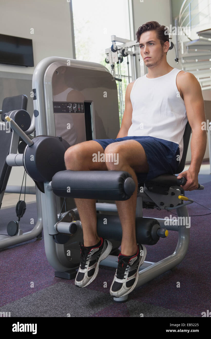 Fit man using weights machine for legs Stock Photo - Alamy