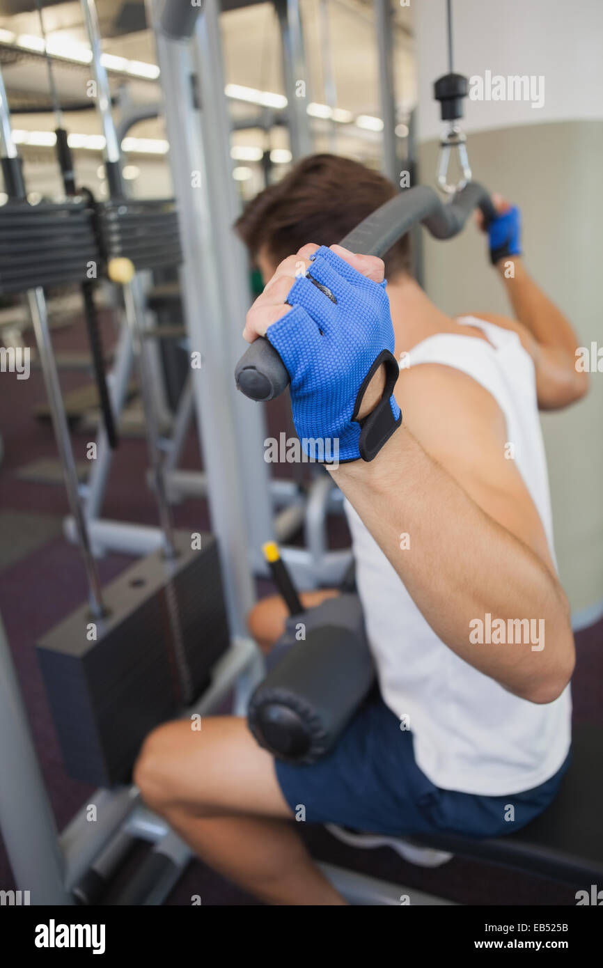 Fit man using weights machine for arms Stock Photo - Alamy