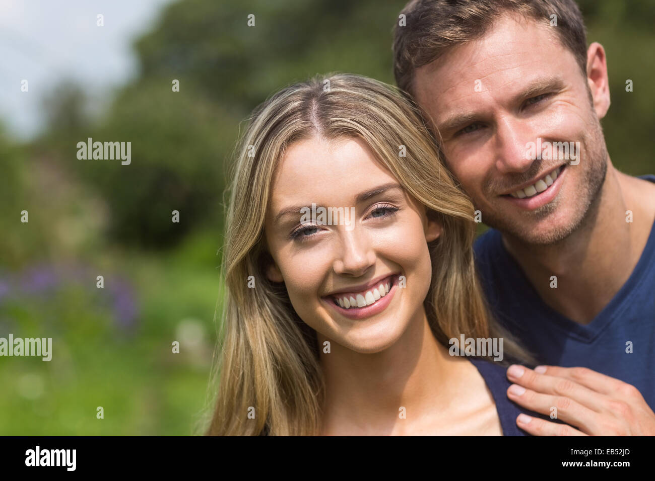 Cute couple smiling at camera Stock Photo - Alamy