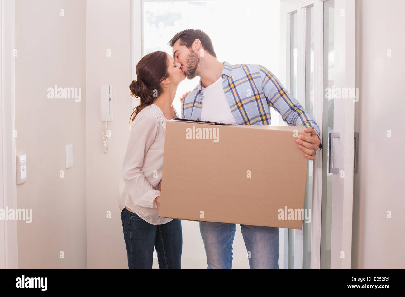 Cute couple carrying cardboard box Stock Photo - Alamy