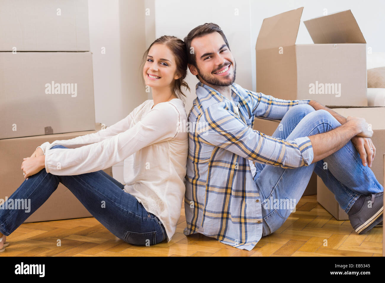 Cute couple sitting on the floor Stock Photo - Alamy