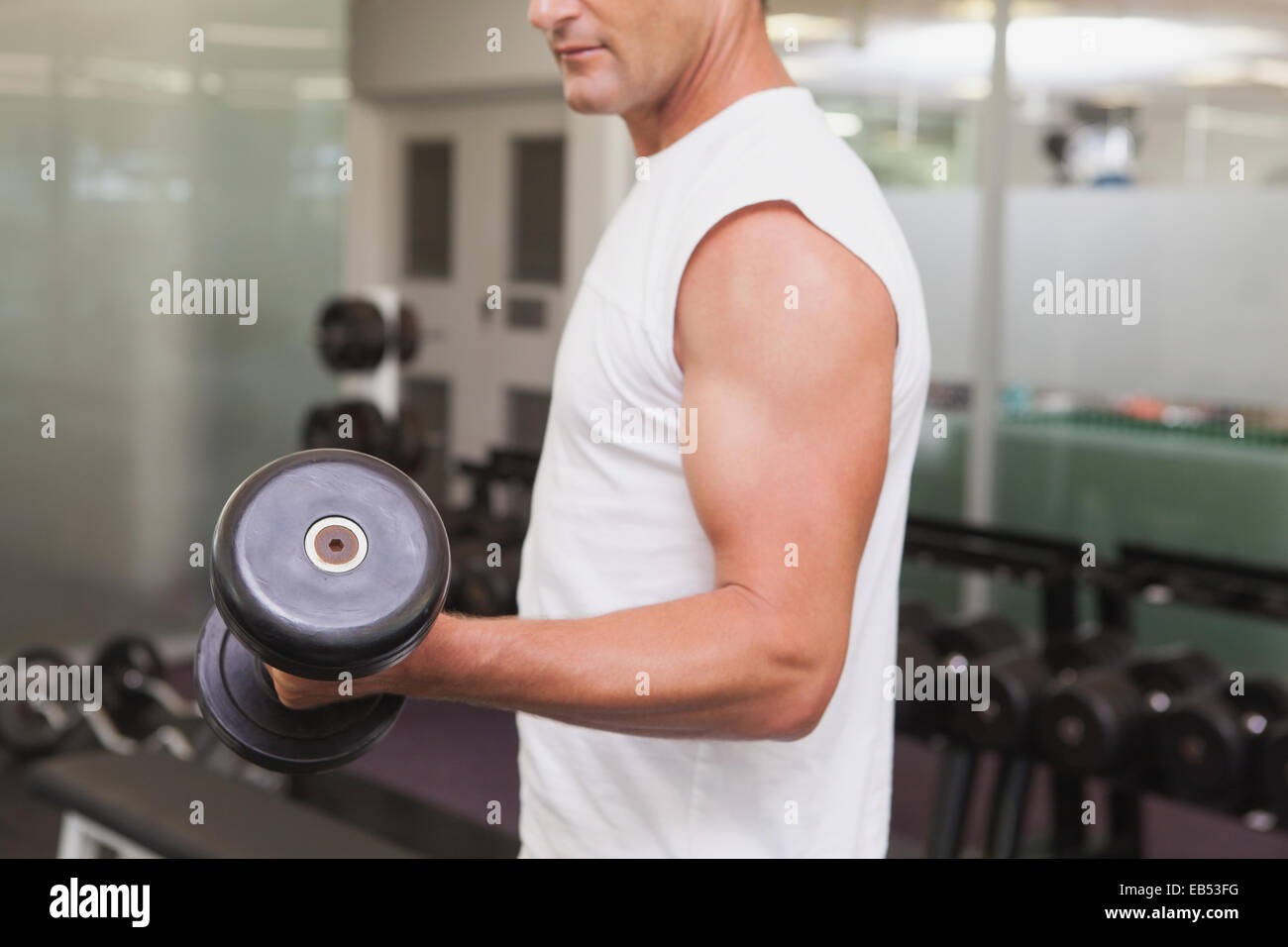 Fit man lifting heavy black dumbbell Stock Photo - Alamy