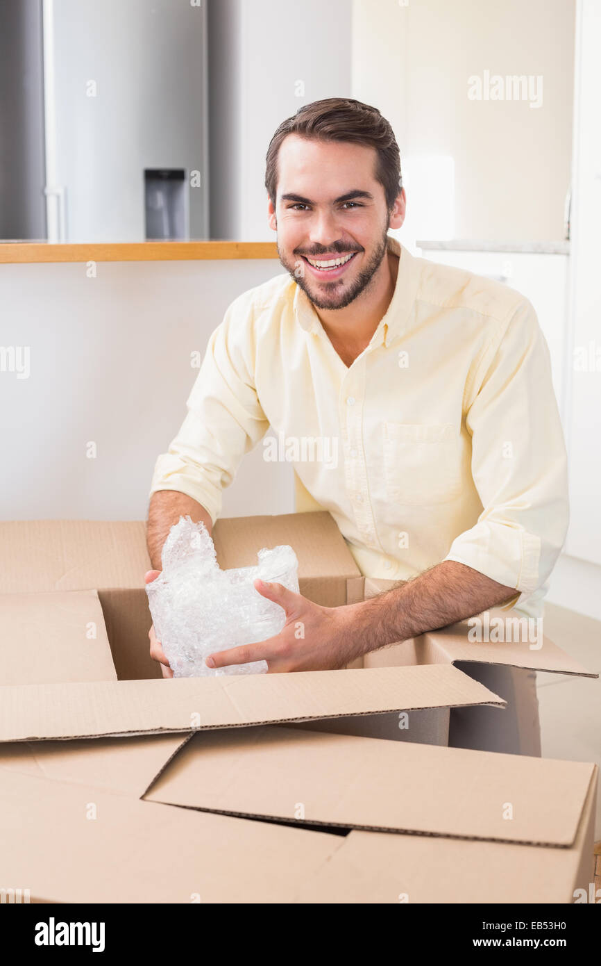 Young man unpacking boxes in kitchen Stock Photo - Alamy