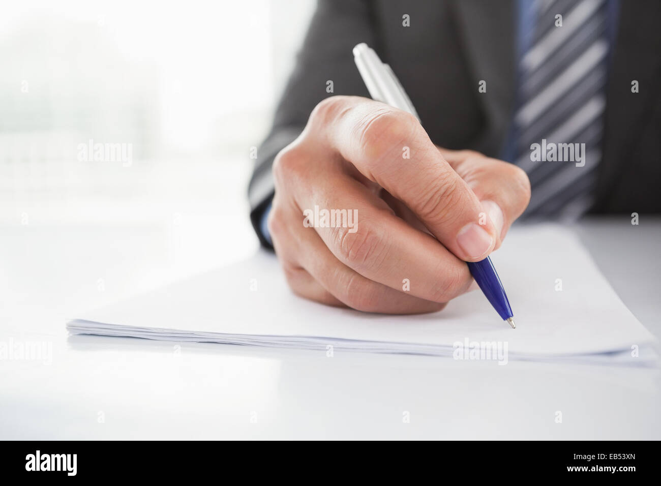 Mature businessman writing on document Stock Photo - Alamy