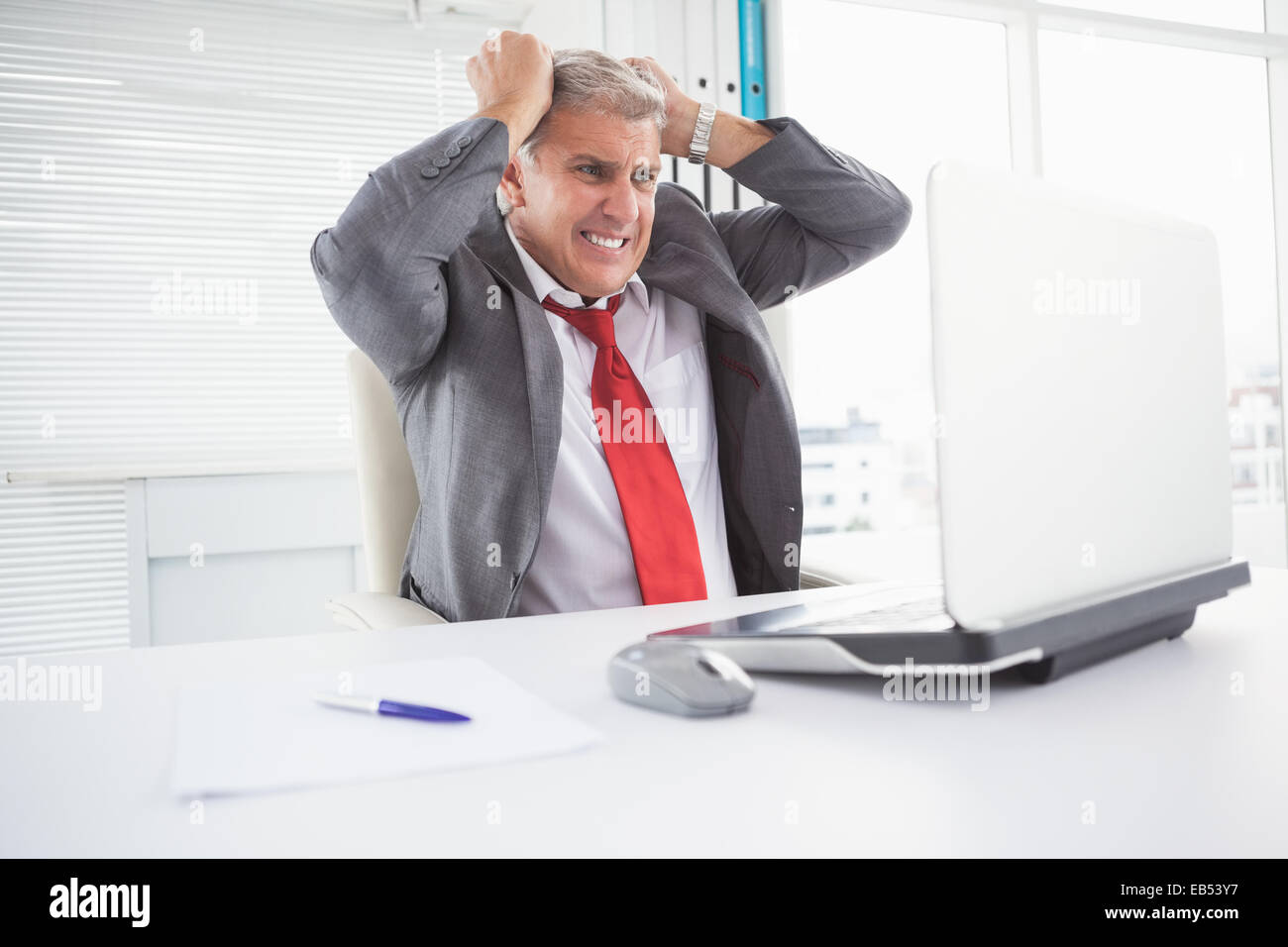 Stressed businessman at his desk Stock Photo - Alamy