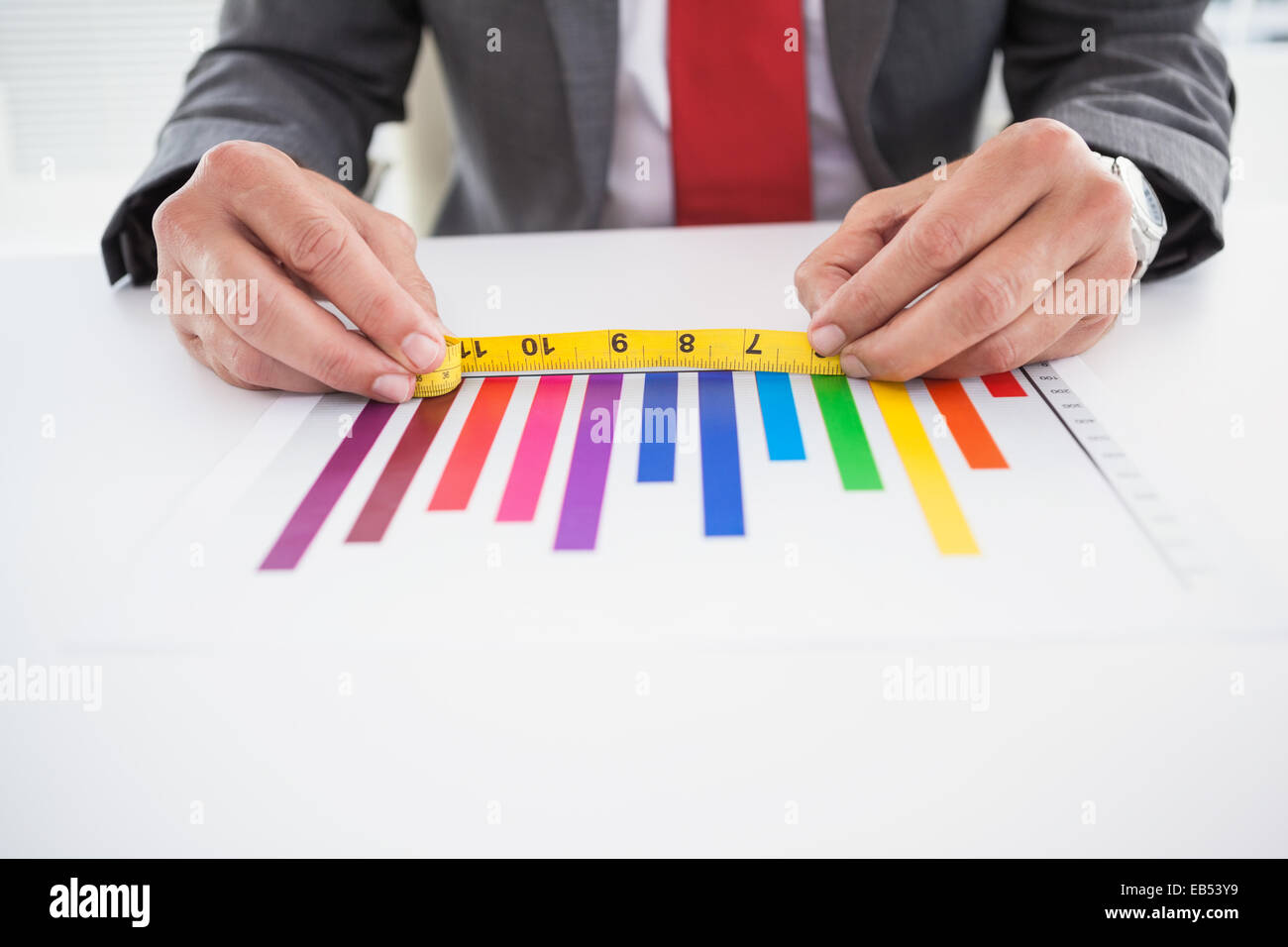 Businessman measuring graph with tape Stock Photo - Alamy
