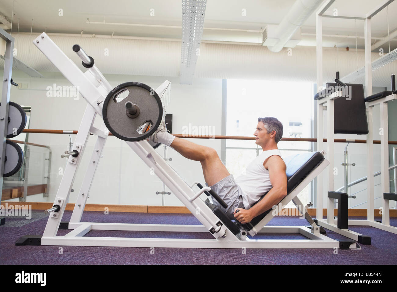 Fit man lifting heavy barbell with legs Stock Photo - Alamy
