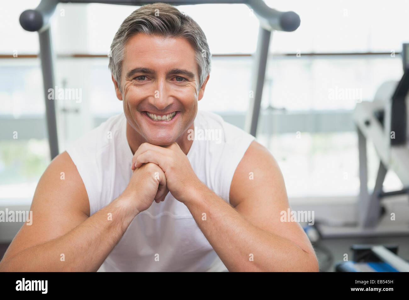Fit man smiling at camera in fitness studio Stock Photo - Alamy