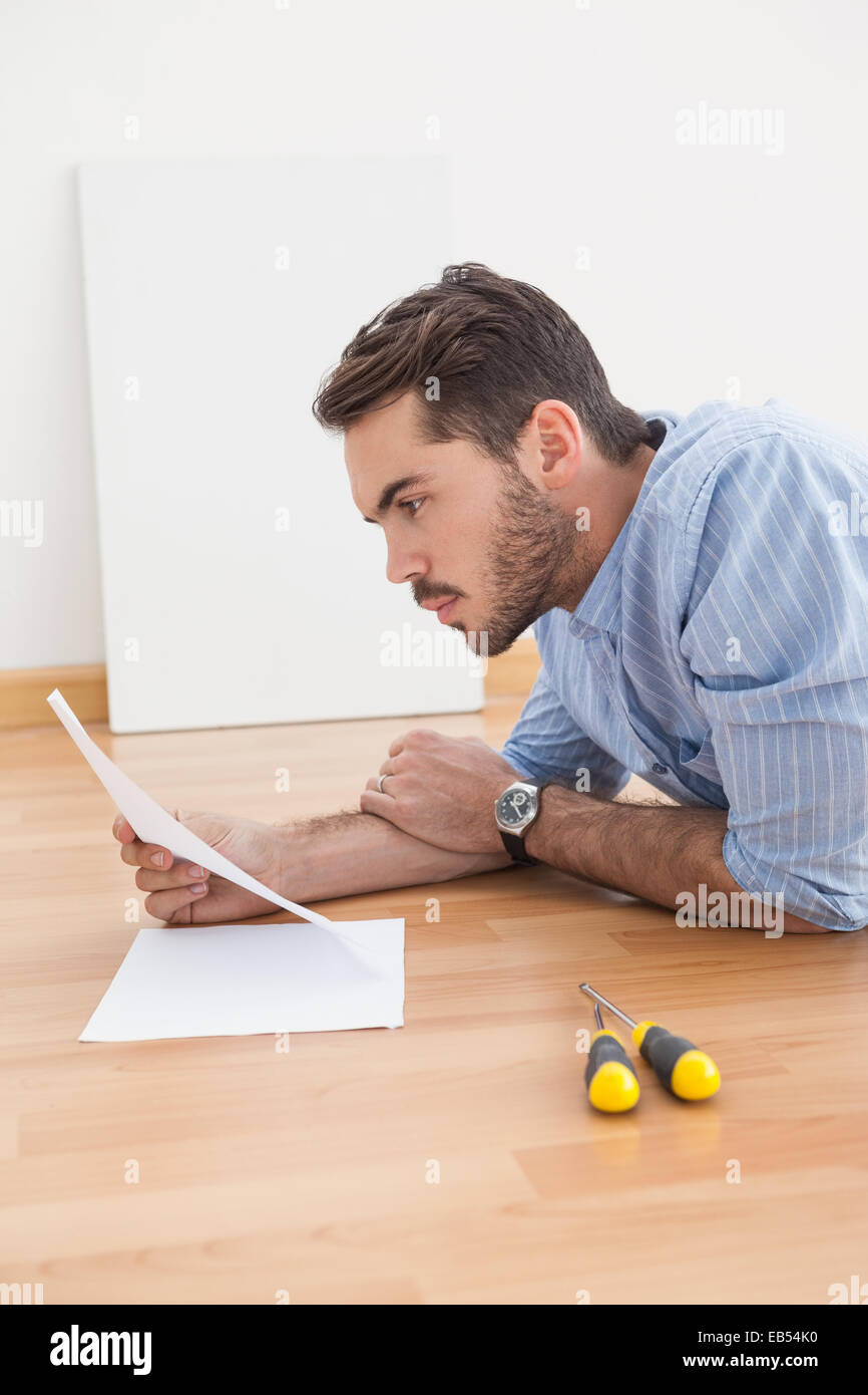 Casual man reading instruction manual for power tool Stock Photo - Alamy