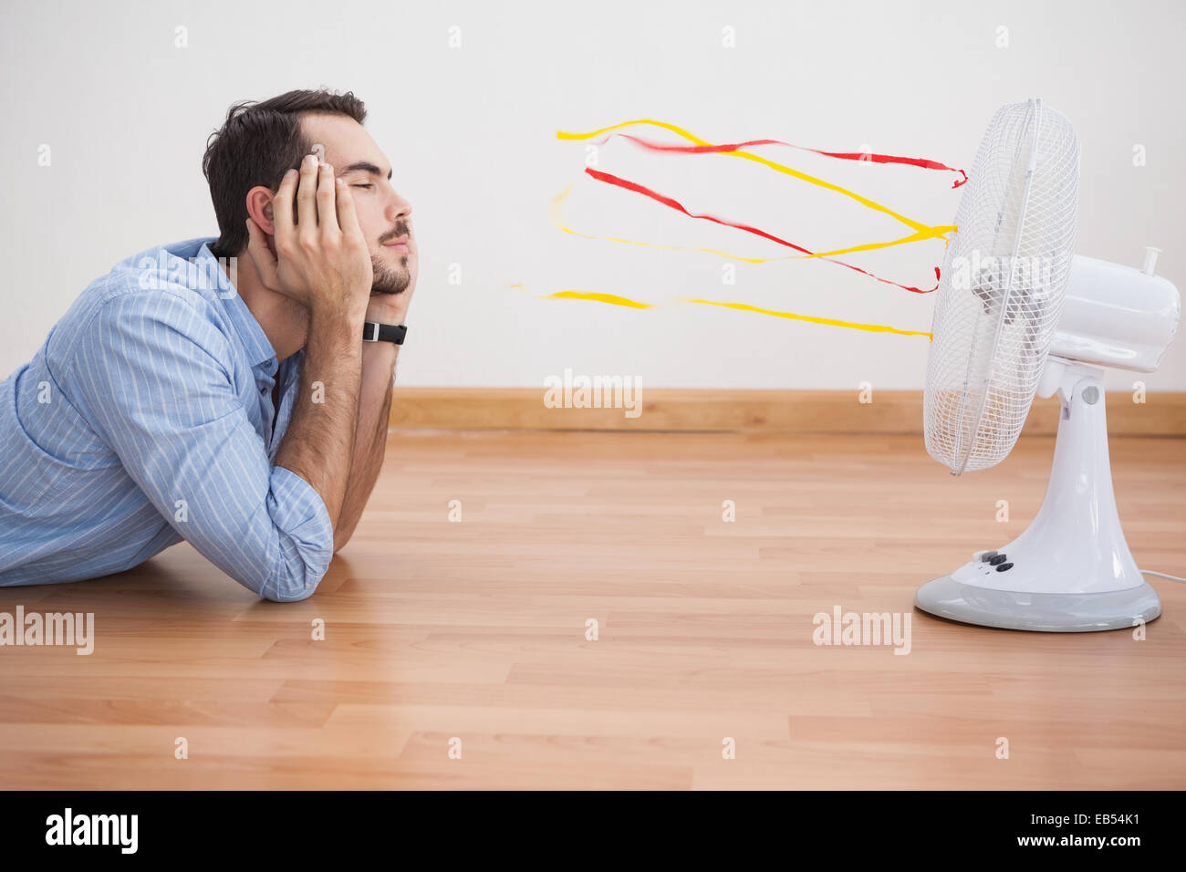 Casual man lying in front of fan Stock Photo - Alamy