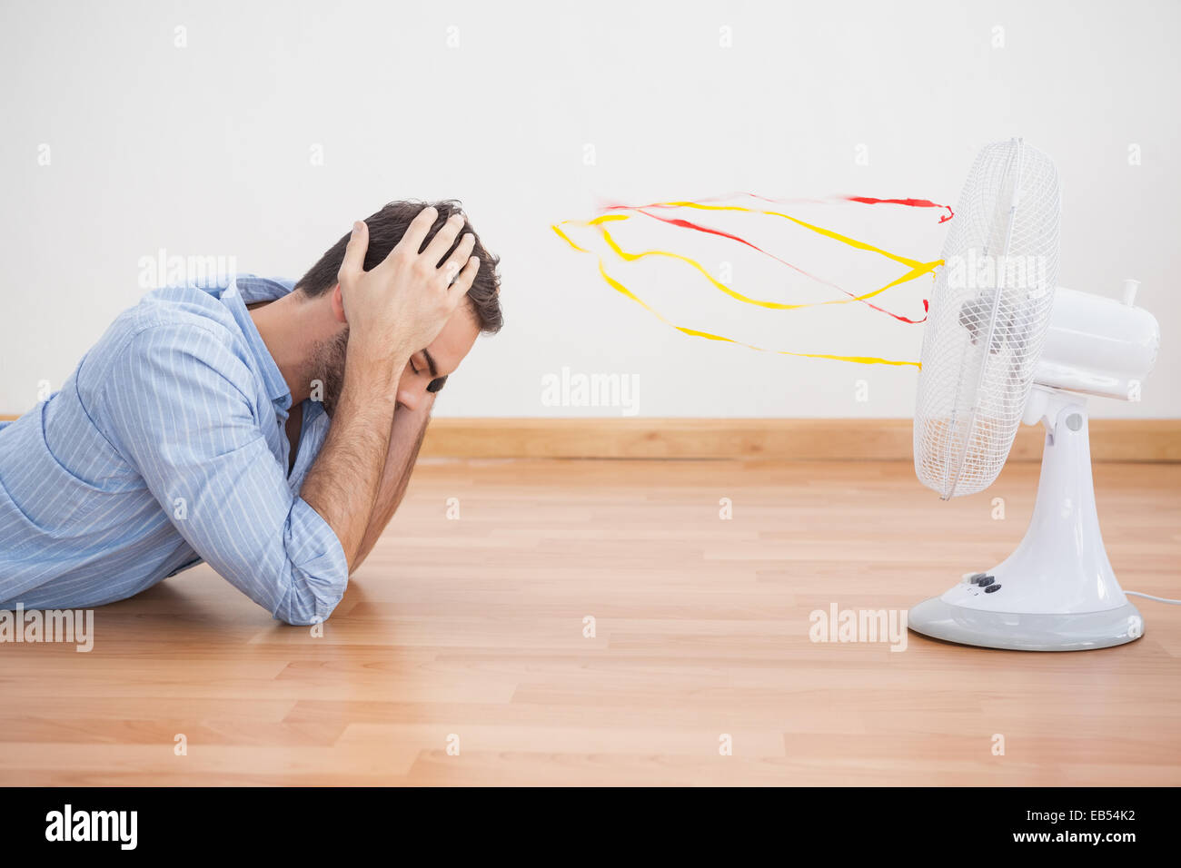 Casual man lying in front of fan Stock Photo - Alamy