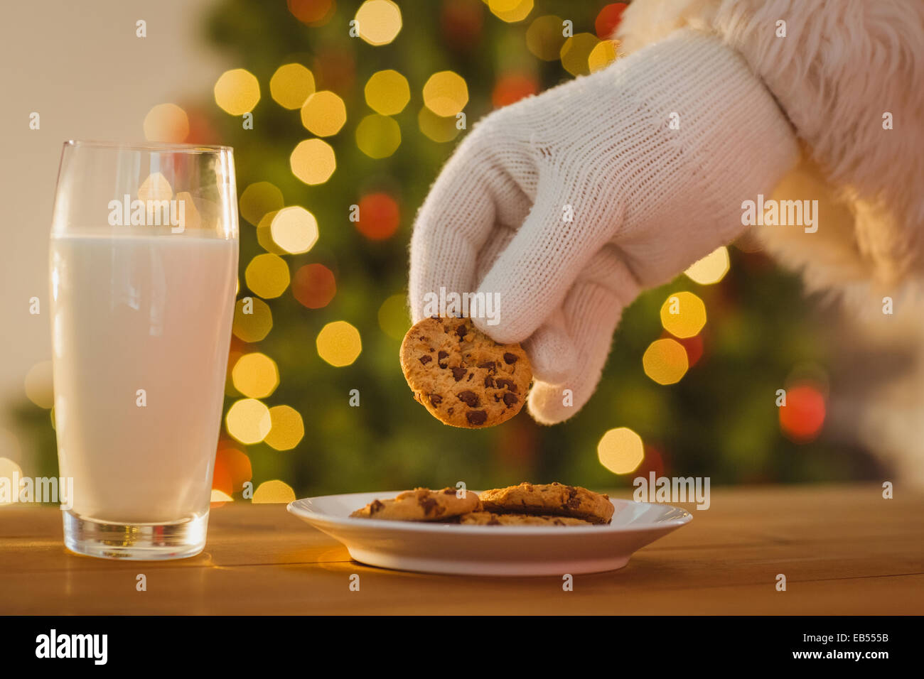 Hand of santa claus picking cookie Stock Photo - Alamy