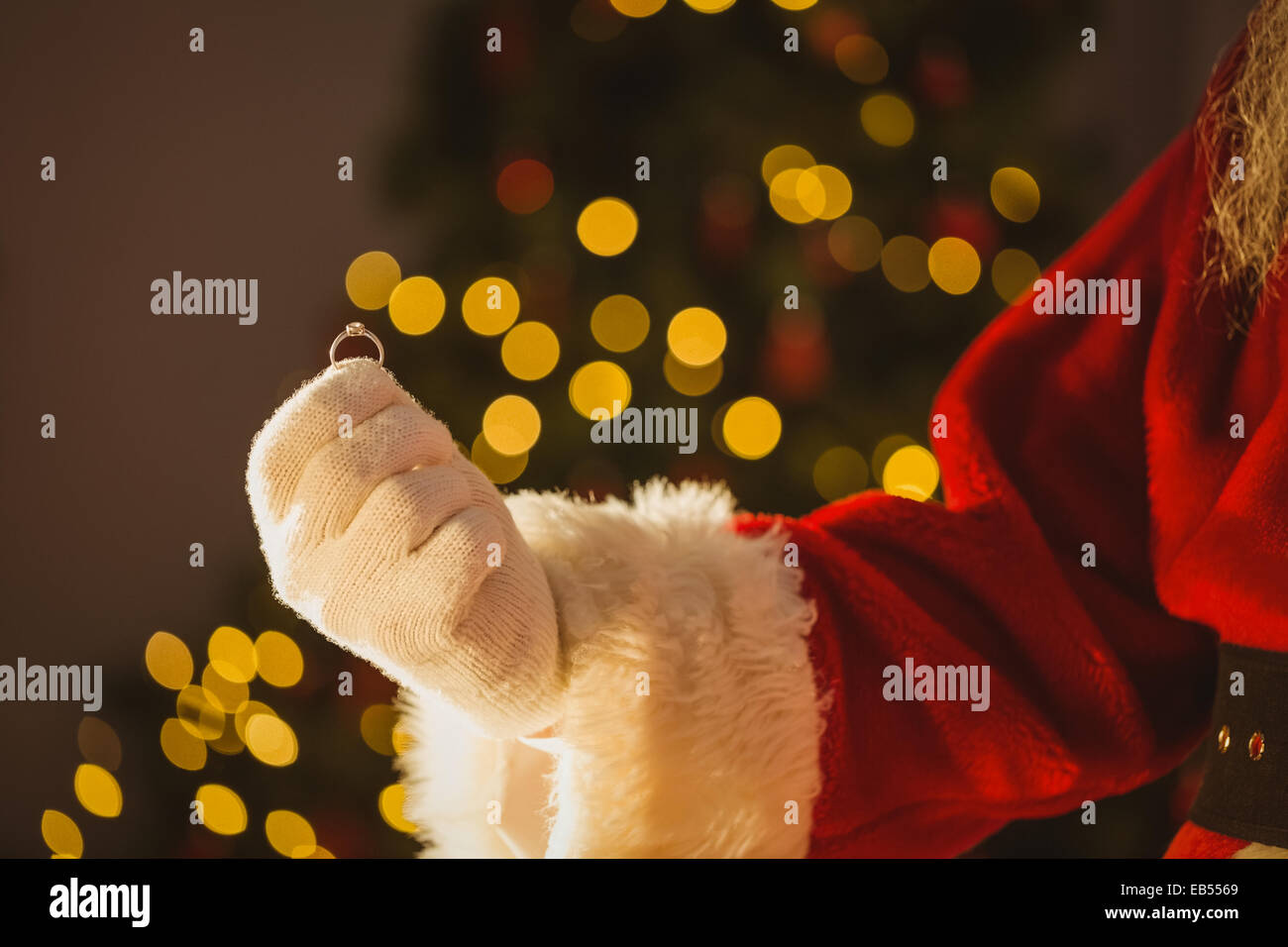 Hand of santa claus holding engagement ring Stock Photo - Alamy