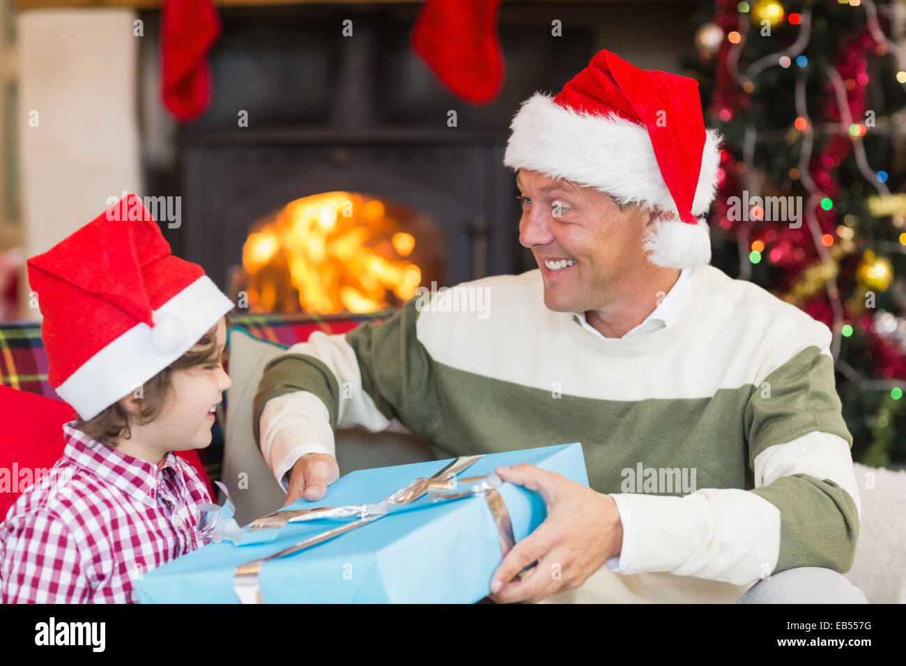 Son giving father a christmas gift on the couch Stock Photo - Alamy